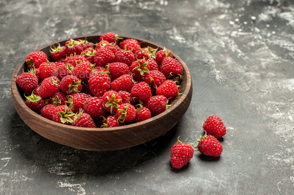 front view fresh red raspberries inside plate on a grey background ...