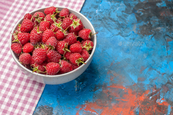 half-top view red raspberries inside plate on blue background photo ...