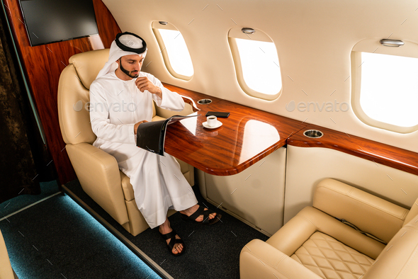 Arabian man wearing kandora flying on private jet Stock Photo by ...