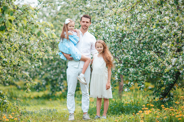 Adorable family in blooming cherry garden on beautiful spring day Stock ...