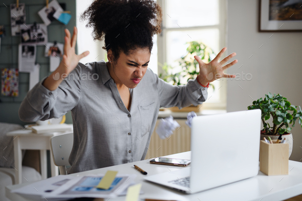 Frustrated young woman with laptop indoors at home, home office concept ...