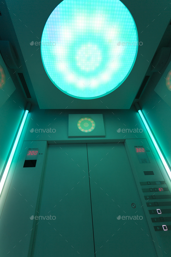 Interior of a futuristic elevator with green light Stock Photo by piccaya