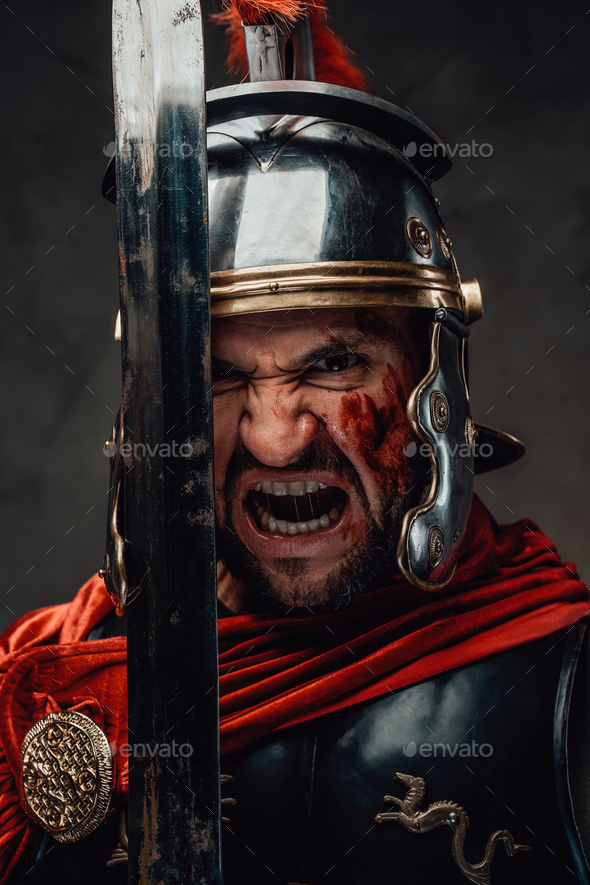 Mad roman warrior screaming holding his sword Stock Photo by fxquadro
