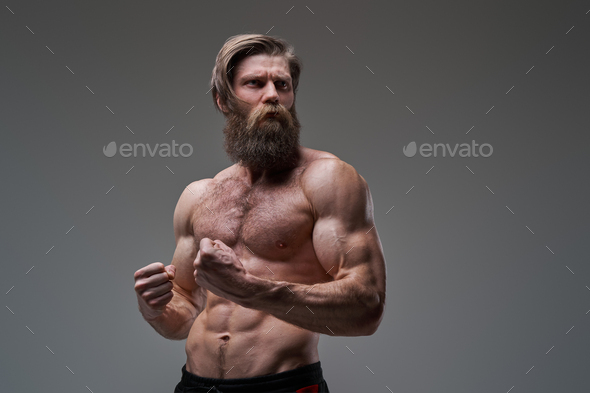 Angry bodybuilder with fists looks away in gray background Stock Photo ...