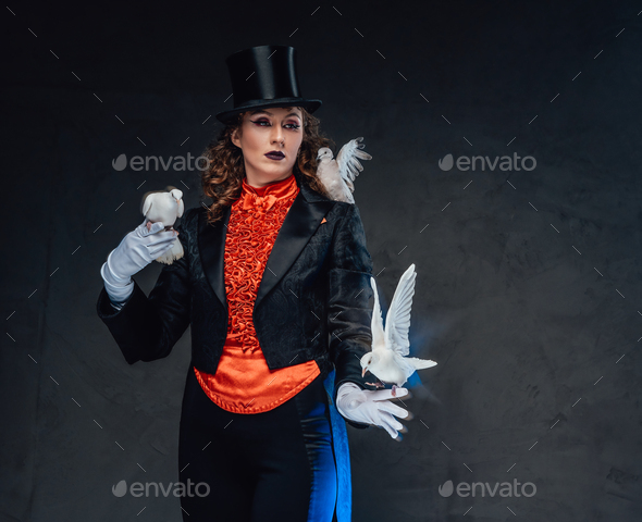 Charming female conjurer and little cute doves in dark background Stock ...