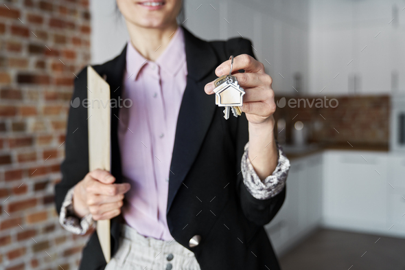 Close up of real estate agent holding house key Stock Photo by gpointstudio