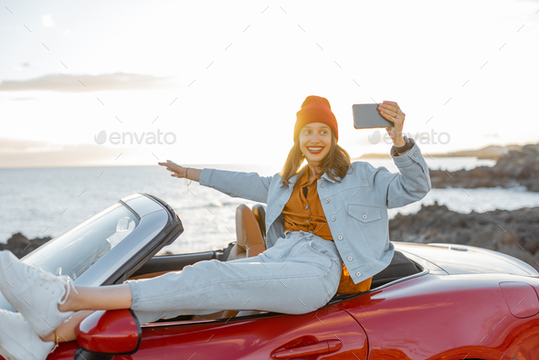 Woman vlogging on phone while travel on the ocean coast Stock Photo by ...