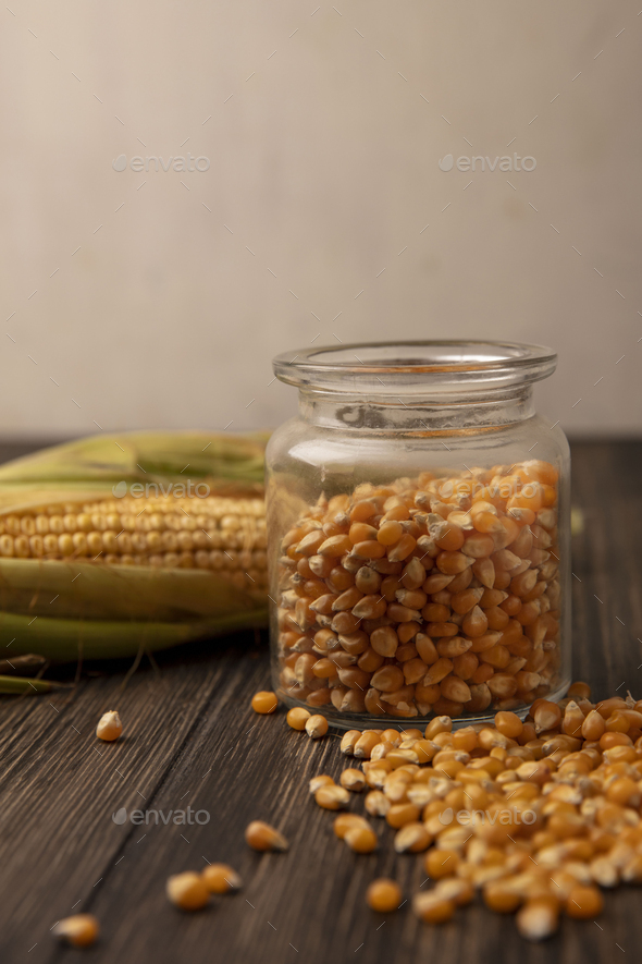 side view of organic and fresh corn kernels on a glass jar with kernels ...