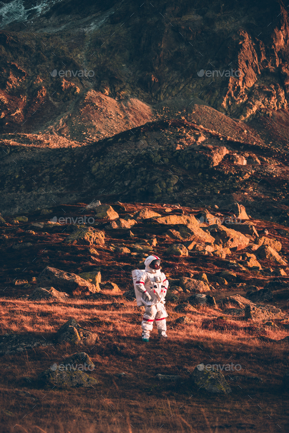Astronaut exploring a new planet. Stock Photo by oneinchpunchphotos
