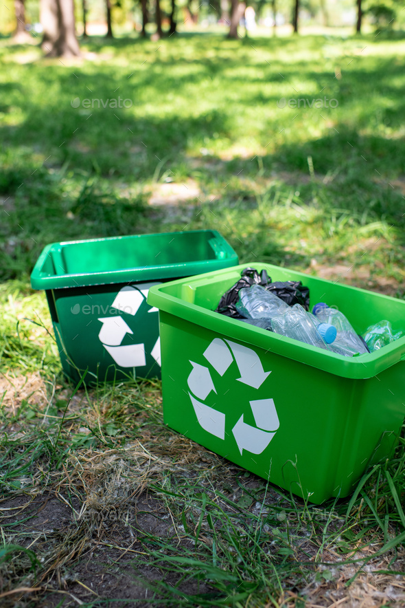 green recycling boxes with trash standing on grass Stock Photo by ...