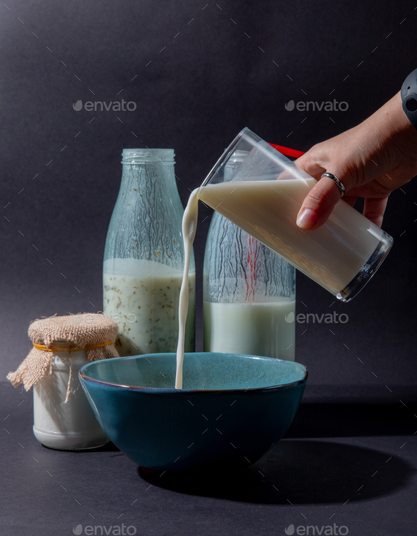 side view of milk products as bottle of milk, cream in jar and female ...