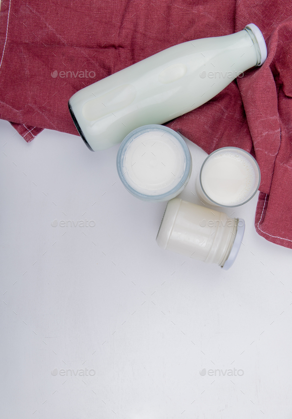 top view of milk products as milk, sour clotted milk and cream on bordo ...