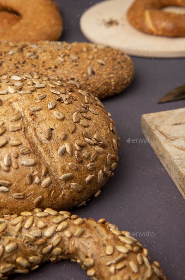 side view of breads as bagel, cob on maroon background Stock Photo by ...