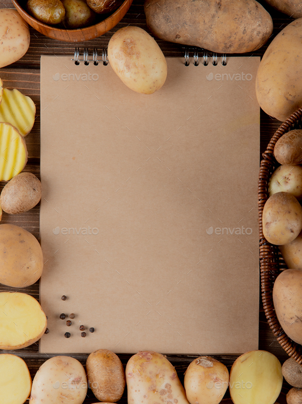 top view of whole and cut potato with black pepper and note pad with ...