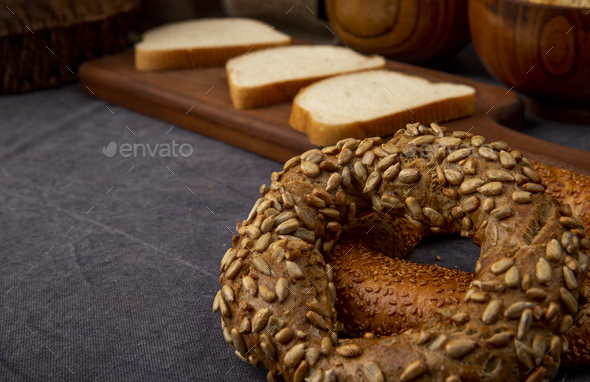 side view of turkish bagels with sliced white bread on maroon ...