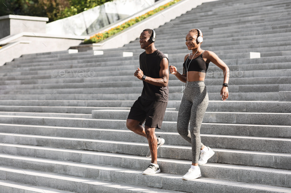 Active Black Athlete Couple Running Outdoors On Steps In Urban Park ...