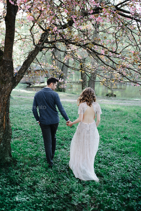 Beautiful happy bride and groom being showered with confetti from ...