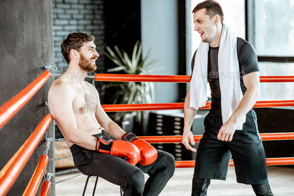 Boxing trainer with boxer on the boxing ring Stock Photo by RossHelen