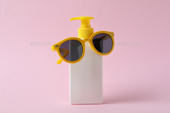 Sunscreen bottle and sunglasses on pink background Stock Photo by ...