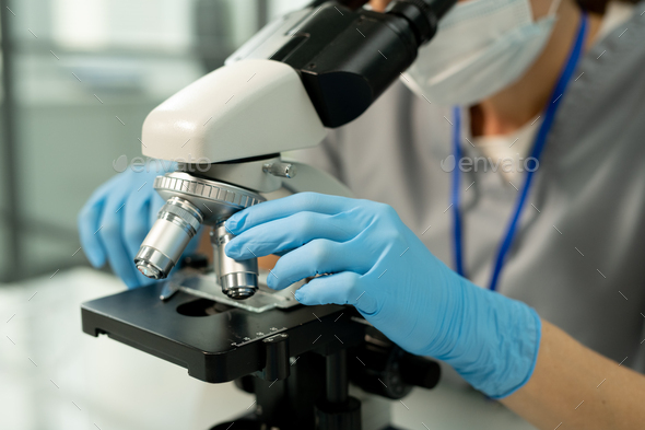 Adjusting microscope slide in laboratory Stock Photo by Pressmaster