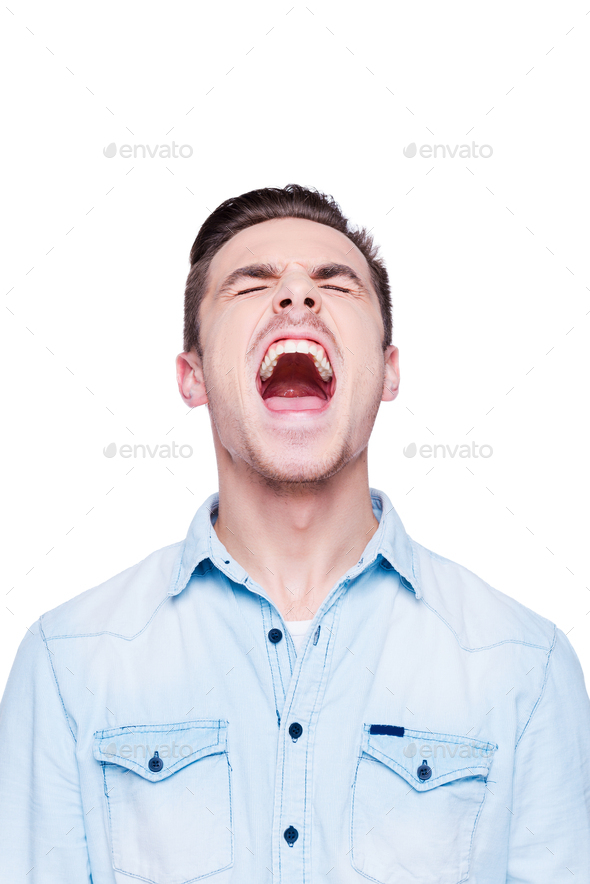 Cry of despair. Handsome young man shouting while standing against ...