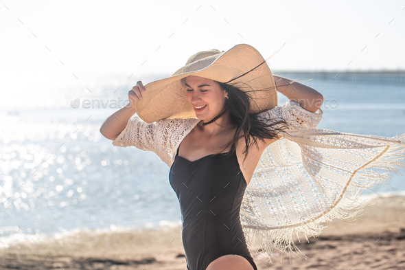 Beautiful woman in hat and bathing suit on the beach. Stock Photo by ...
