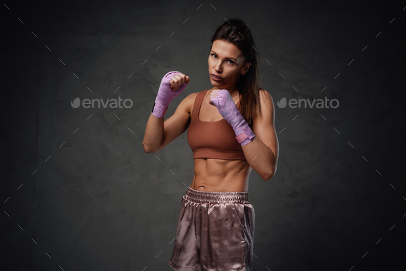 Female fighter staying in fighting stance in dark background Stock ...