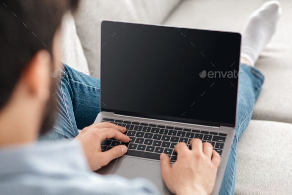 Technology concept. Unrecognizable guy using laptop computer with blank ...