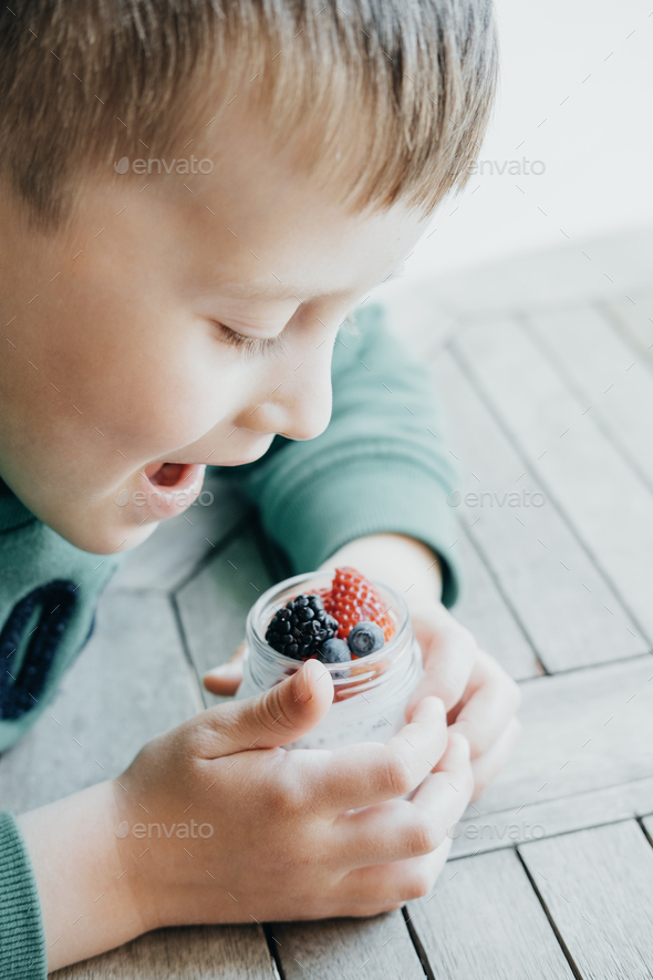 Cute Boy eating Pudding with chia seeds, yogurt and fresh fruits Stock ...