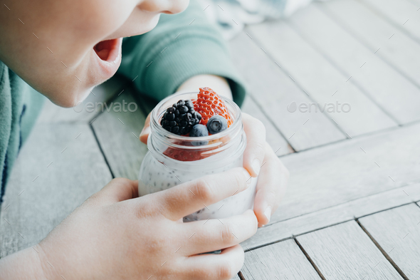 Boy eating Pudding with chia seeds, yogurt and fresh fruits Stock Photo ...