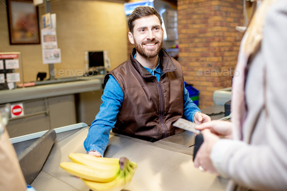 Happy cashier at the cash register Stock Photo by RossHelen | PhotoDune