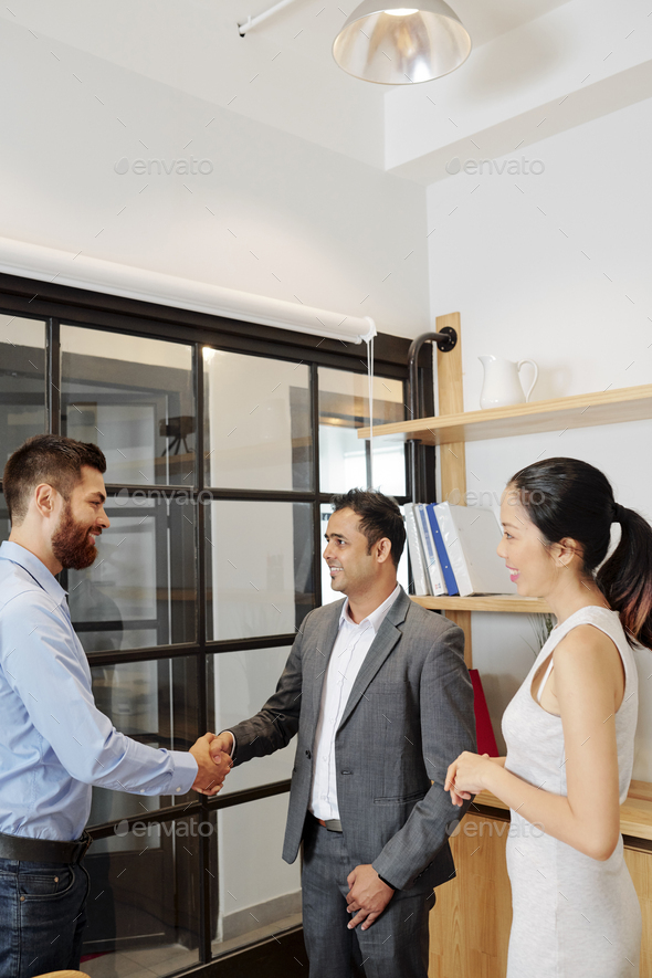 Smiling entrepreneurs shaking hands Stock Photo by DragonImages | PhotoDune