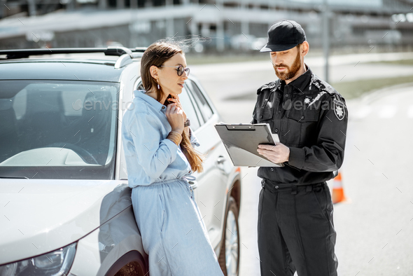 Policeman with female driver on the roadside Stock Photo by RossHelen