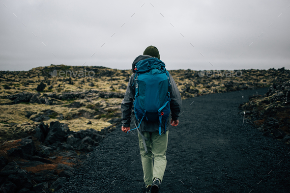 Adventure man walk in icelandic landscape alone Stock Photo by bublikhaus