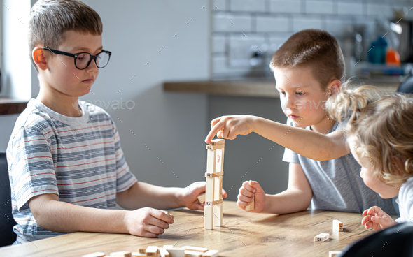 Children play a board game with a wooden turret at home. Stock Photo by ...