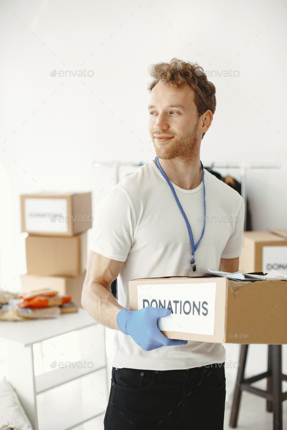 Volunteer guy packs boxes with a humanitarian help Stock Photo by ...