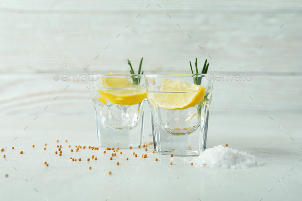 Shots of tequila on white textured table Stock Photo by AtlasComposer