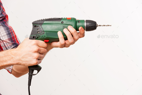 Man using drill. Close-up side view of man using drill while standing ...