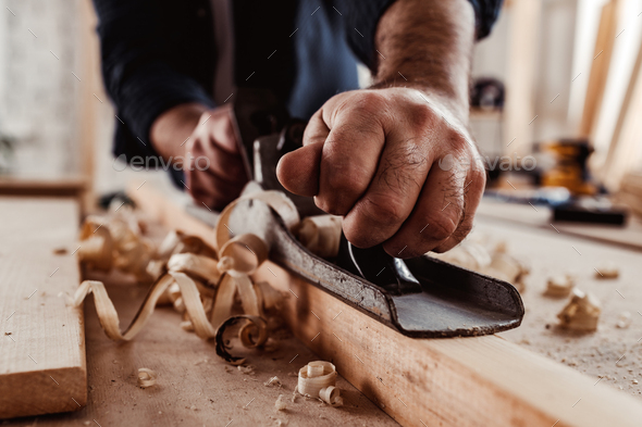 Carpenter's hands planing a plank of wood with a hand plane Stock Photo ...