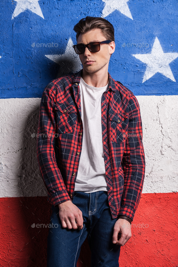 Trendy look. Handsome male model in checked shirt posing against ...