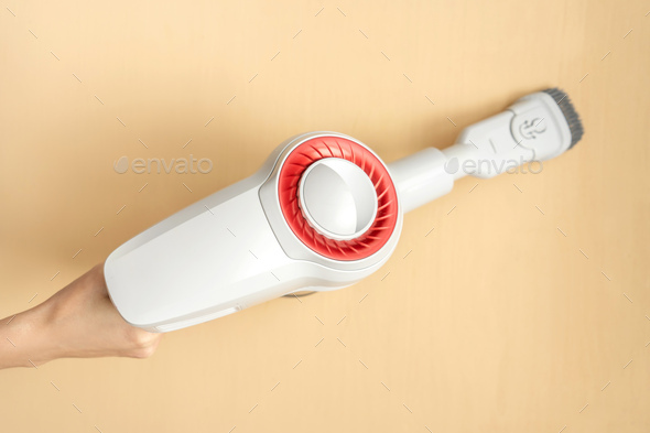 Female hand holding a portable vacuum cleaner. Stock Photo by maksimovata