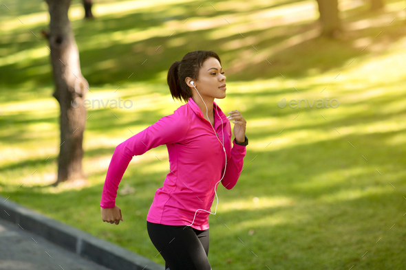 Side view of athletic black woman running by park Stock Photo by ...