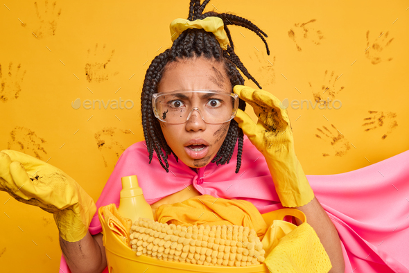 Serious untidy woman with combed dreadlocks being dirty after tidying ...
