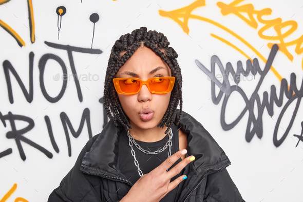 Photo of surprised female rapper with braids makes cool gesture looks ...