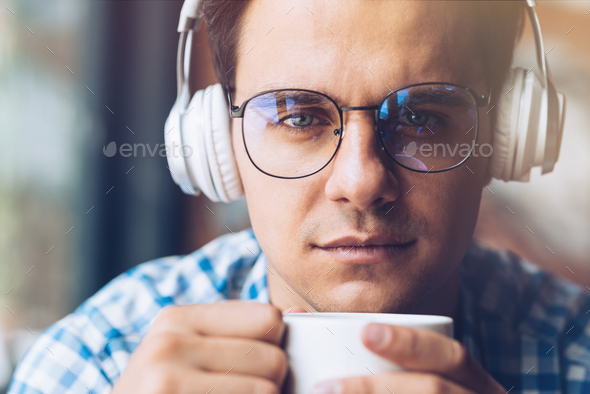 Take a sip. Man drinking coffee and listening to music Stock Photo by ...
