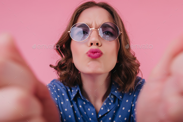 Beautiful woman with bright makeup posing with kissing face expression ...