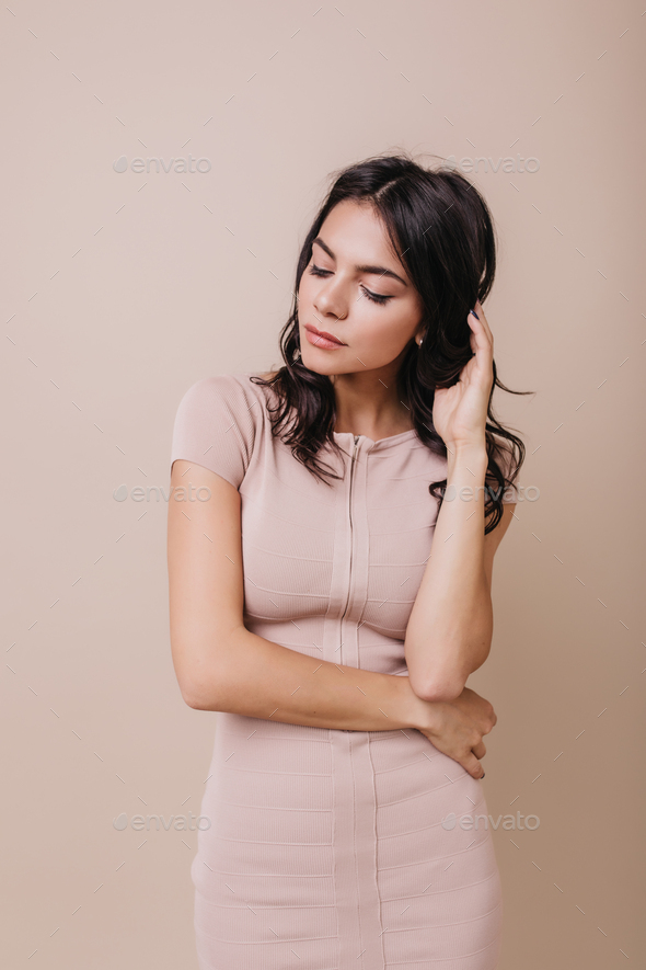 Beautiful intelligent woman touches curly hair. Photo indoors of young ...