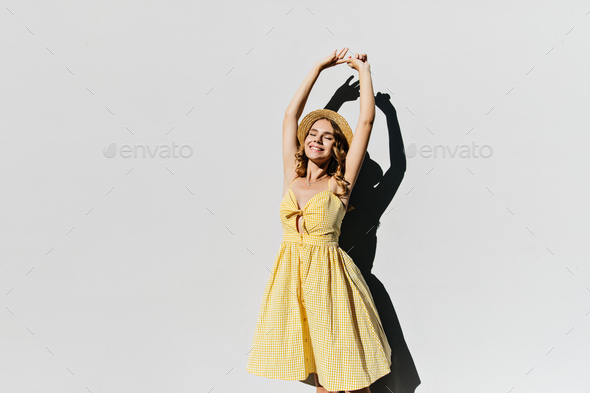 Adorable blonde girl posing with hands up on light background. Outdoor ...