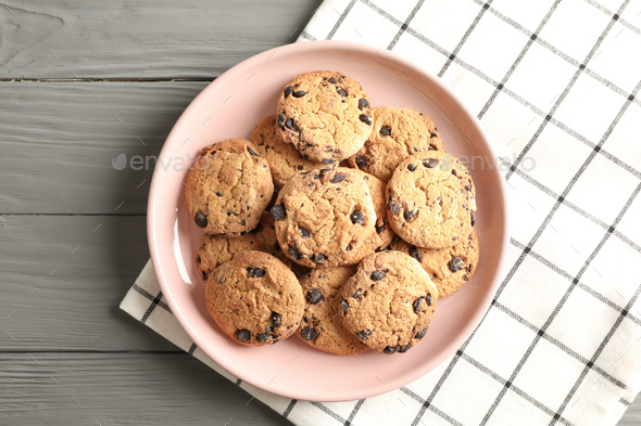 Plate with chocolate chip cookies and space for text on wooden table ...