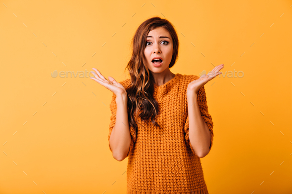 Attractive dissapointed woman posing on yellow background. Emotional ...